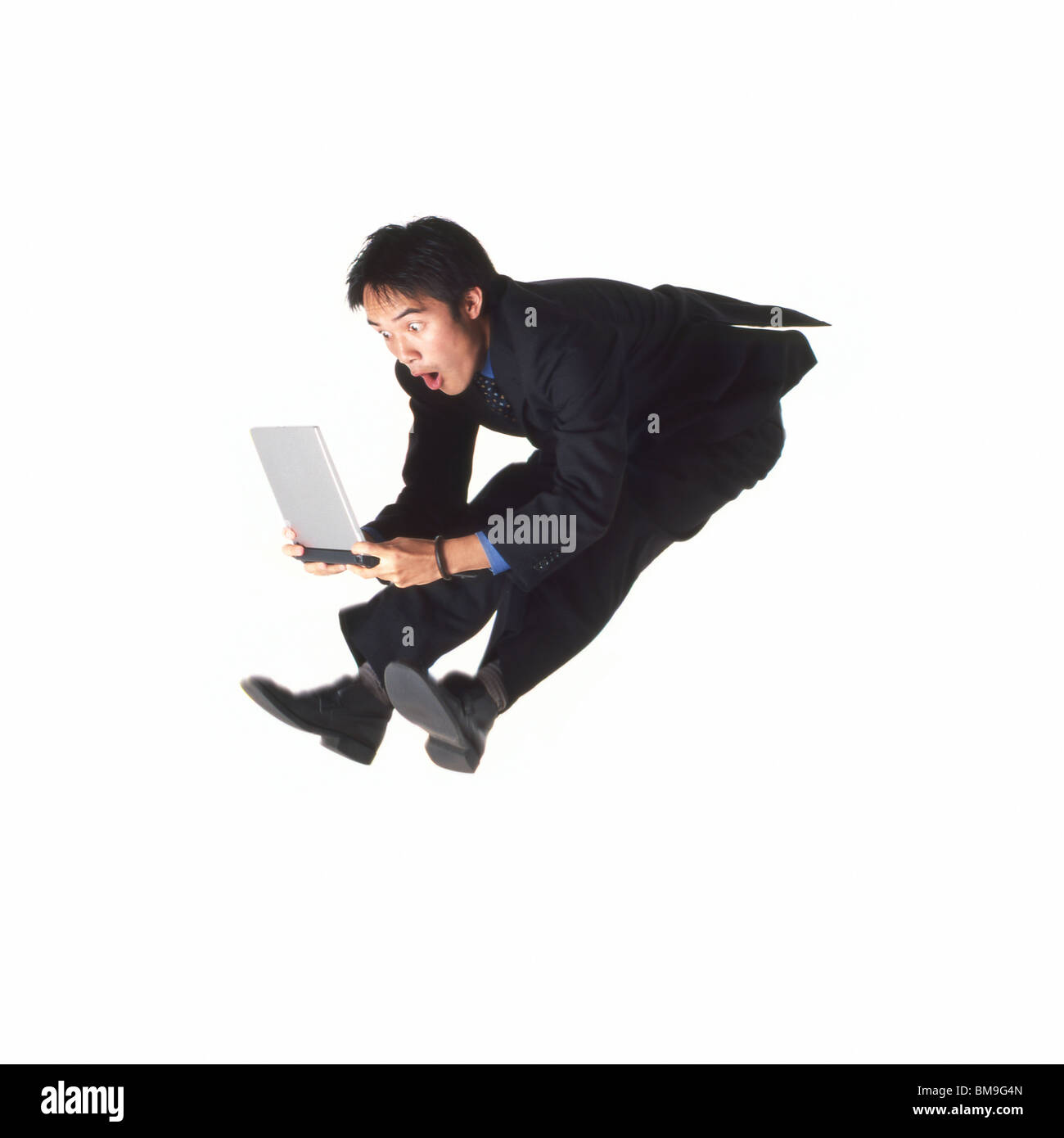 Young businessman jumping with laptop Stock Photo - Alamy