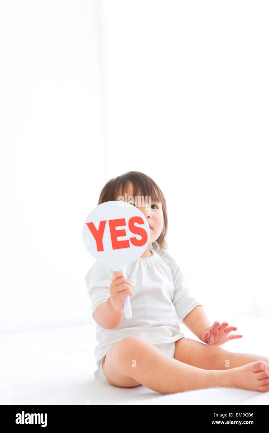 Baby girl holding yes sign Stock Photo - Alamy