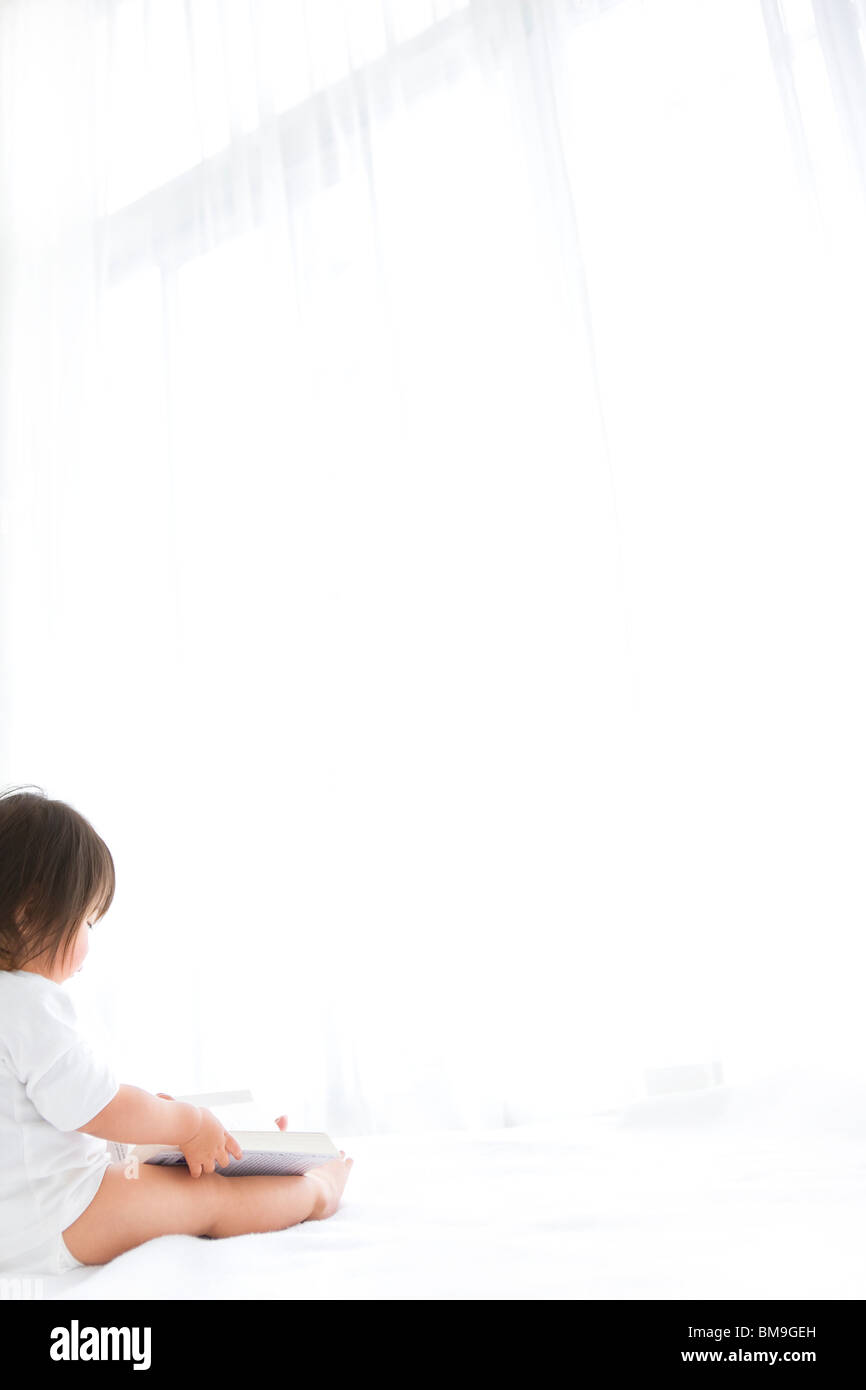 Baby girl with open book Stock Photo - Alamy