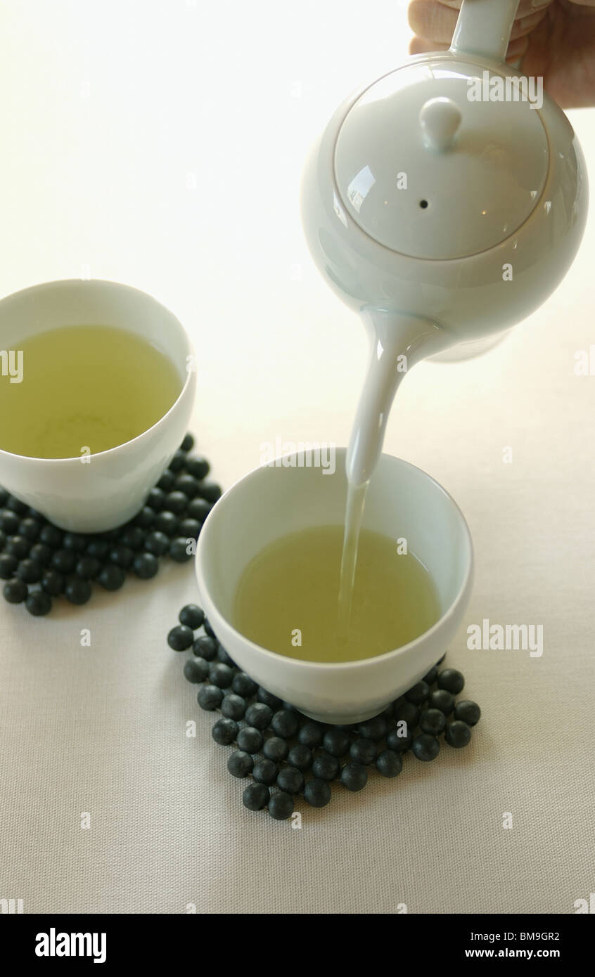 Pouring green tea into a cups Stock Photo - Alamy