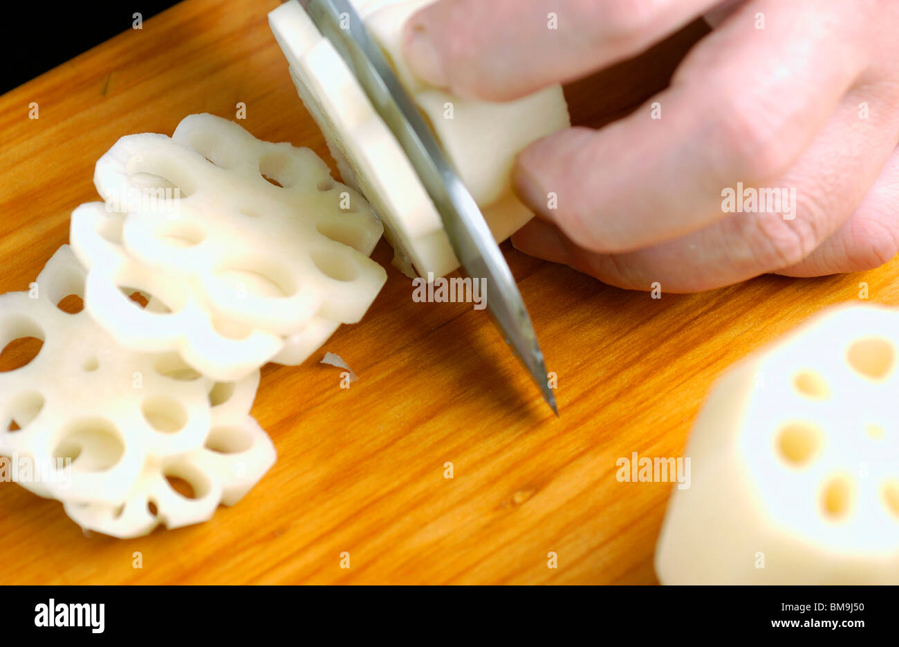 Chef cutting lotus root close up Stock Photo - Alamy