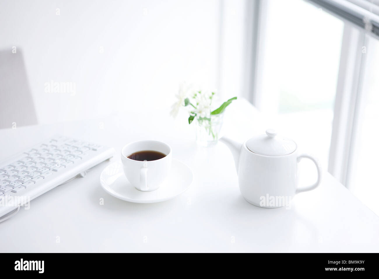 Computer keyboard and cup of coffee on desk in office Stock Photo - Alamy