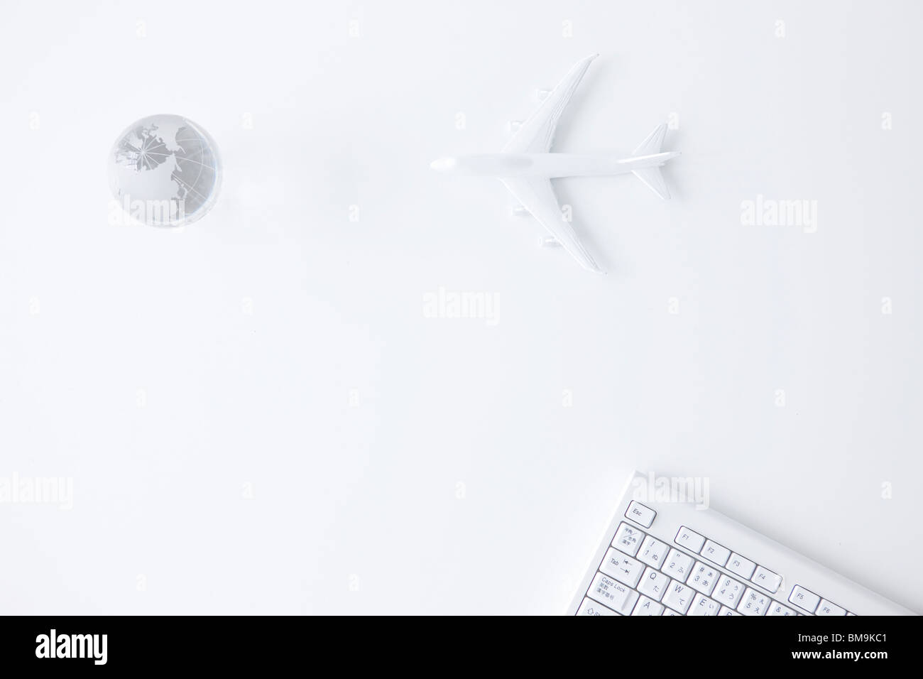 Computer keyboard, globe and toy airplane on white background Stock ...