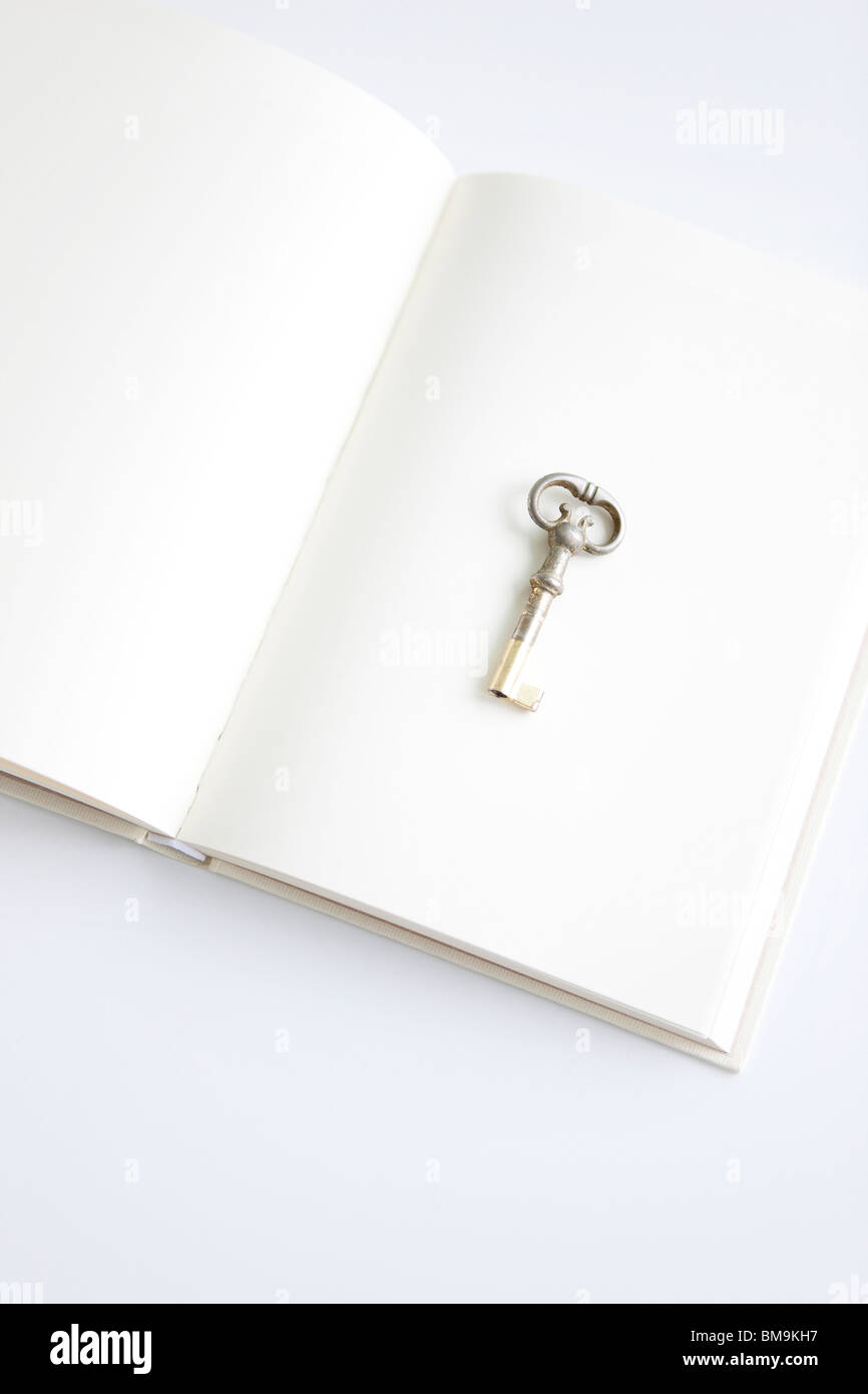 Old key on opened book, white background Stock Photo - Alamy