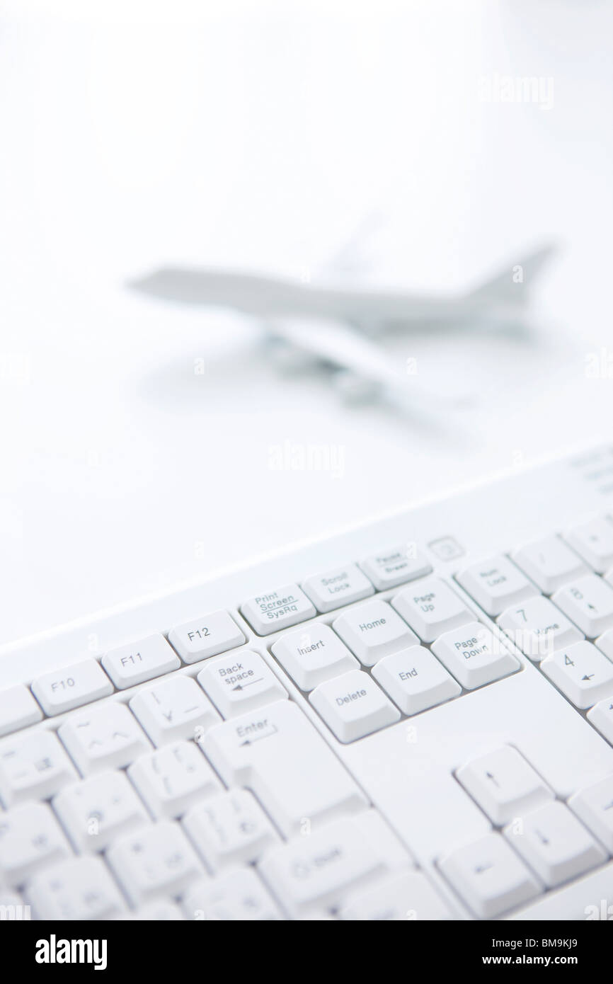 Computer keyboard and toy airplane on white background Stock Photo - Alamy
