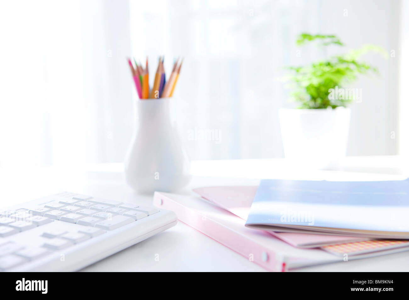Notebooks and colored pencils on desk in office Stock Photo - Alamy