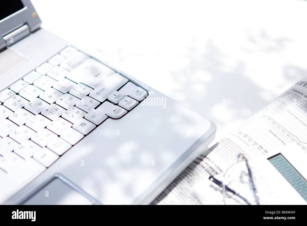 Laptop and newspaper on white background, close up Stock Photo - Alamy