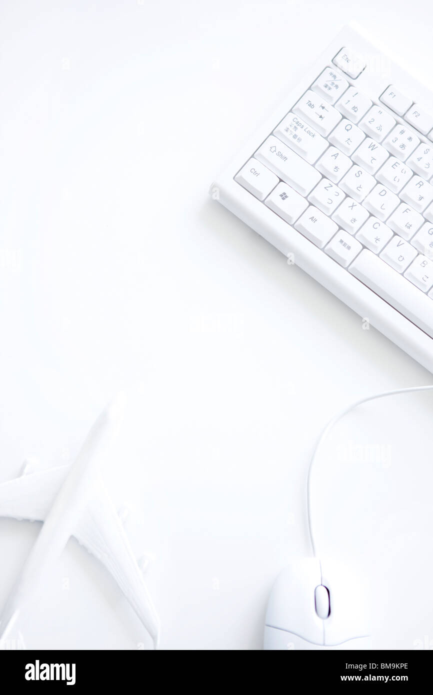 Computer keyboard, computer mouse and toy airplane on white background ...