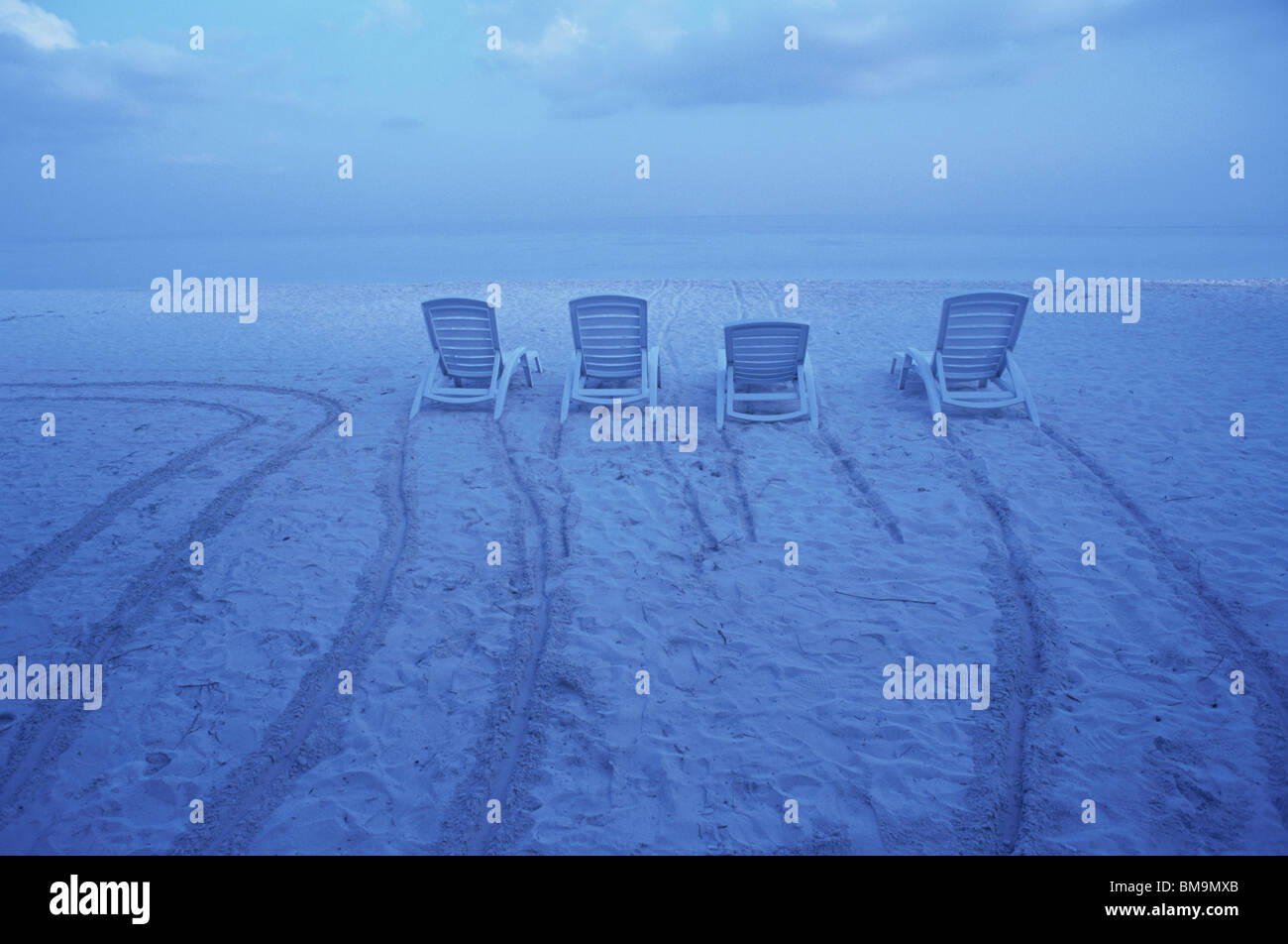 Four deck chairs on beach, Maldives Stock Photo - Alamy
