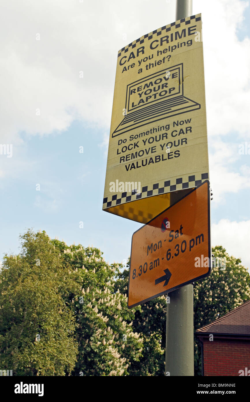 Car Crime warning sign above a parking restriction sign Stock Photo - Alamy