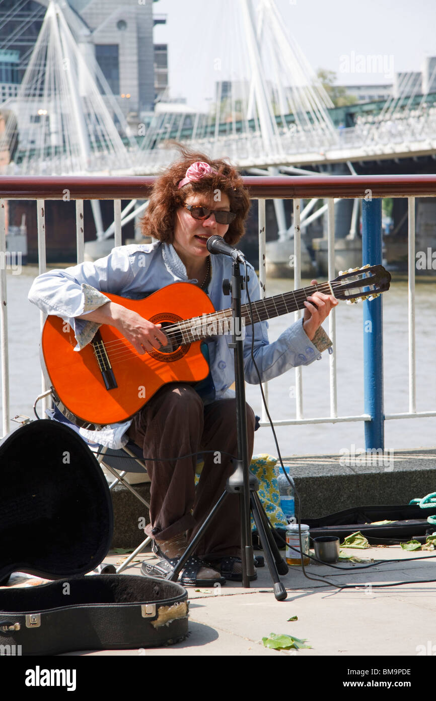 Woman playing guitar singing busking hi-res stock photography and ...