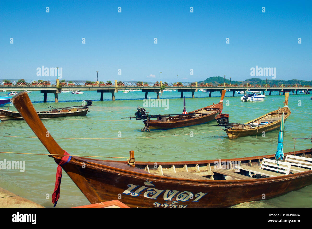 Boats line the beach of Chalong Bay, a popular tourist destination on ...