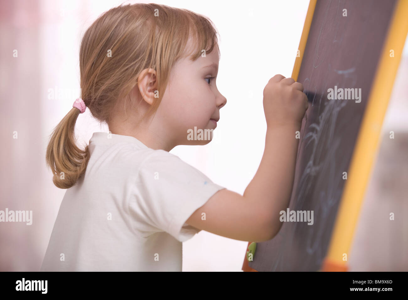 Young girl drawing on chalkboard Stock Photo - Alamy