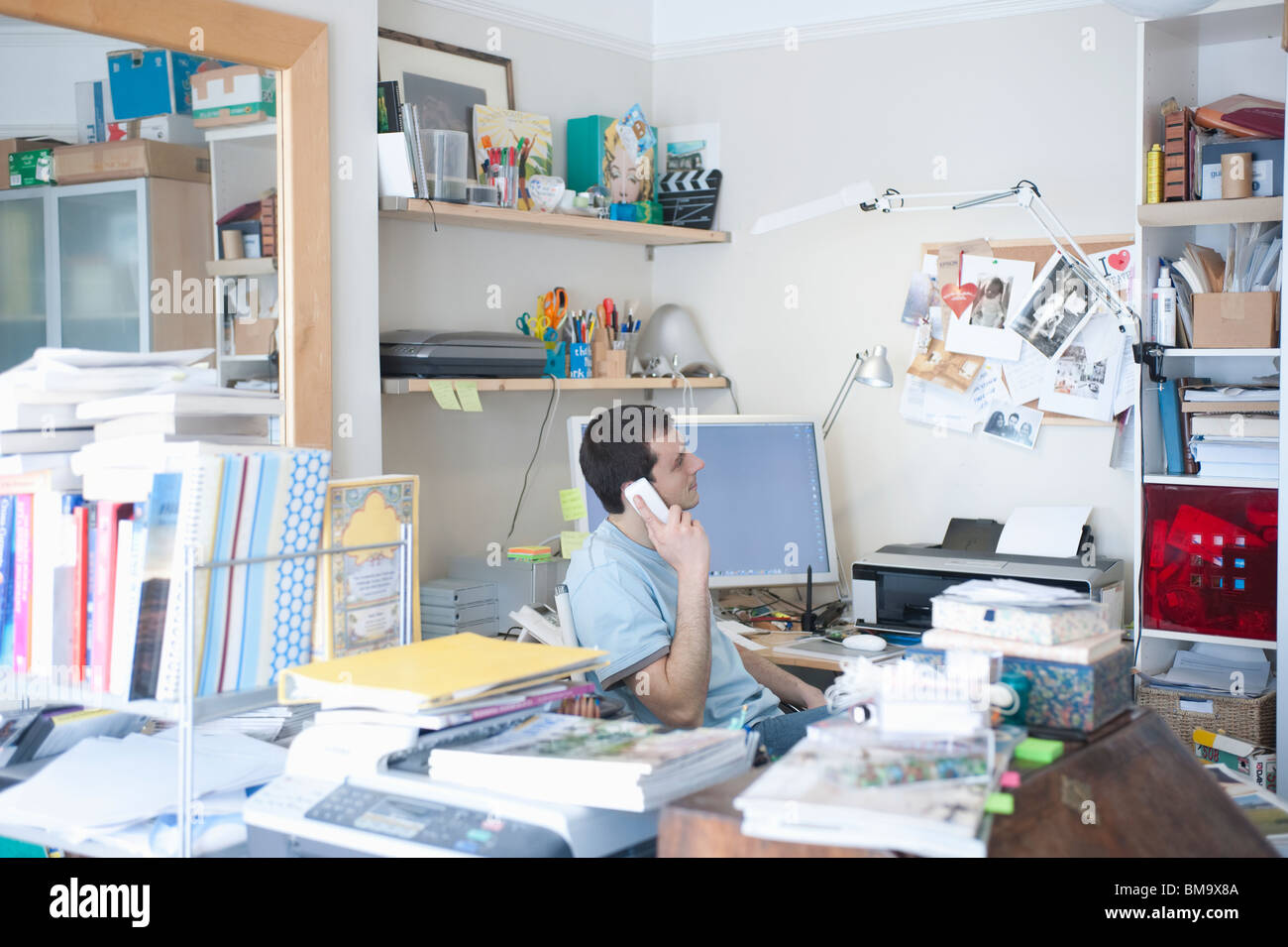 Creative professional sits on phone in corner of office Stock Photo - Alamy