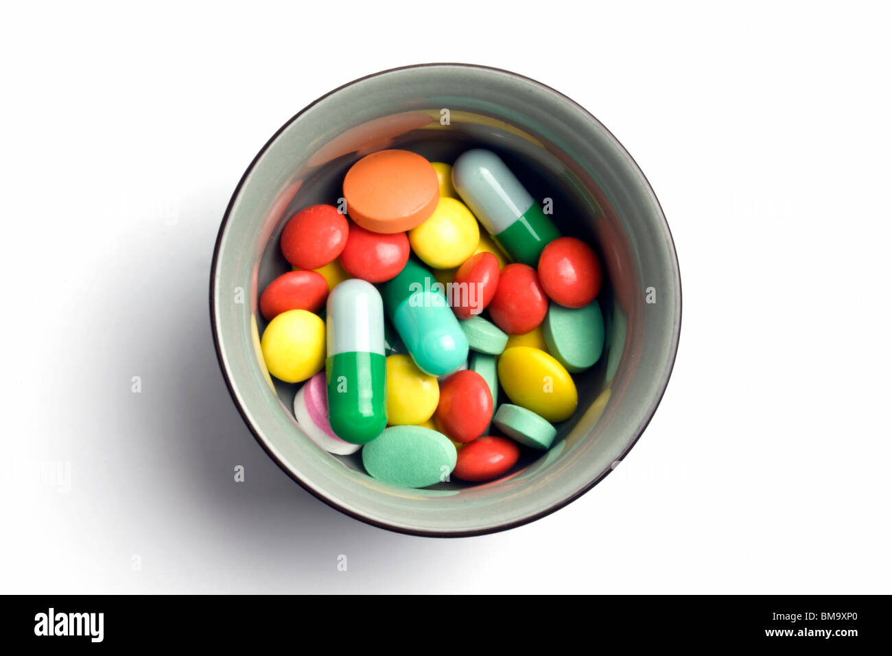Bowl of multicolored tablets and capsules isolated on white Stock Photo ...