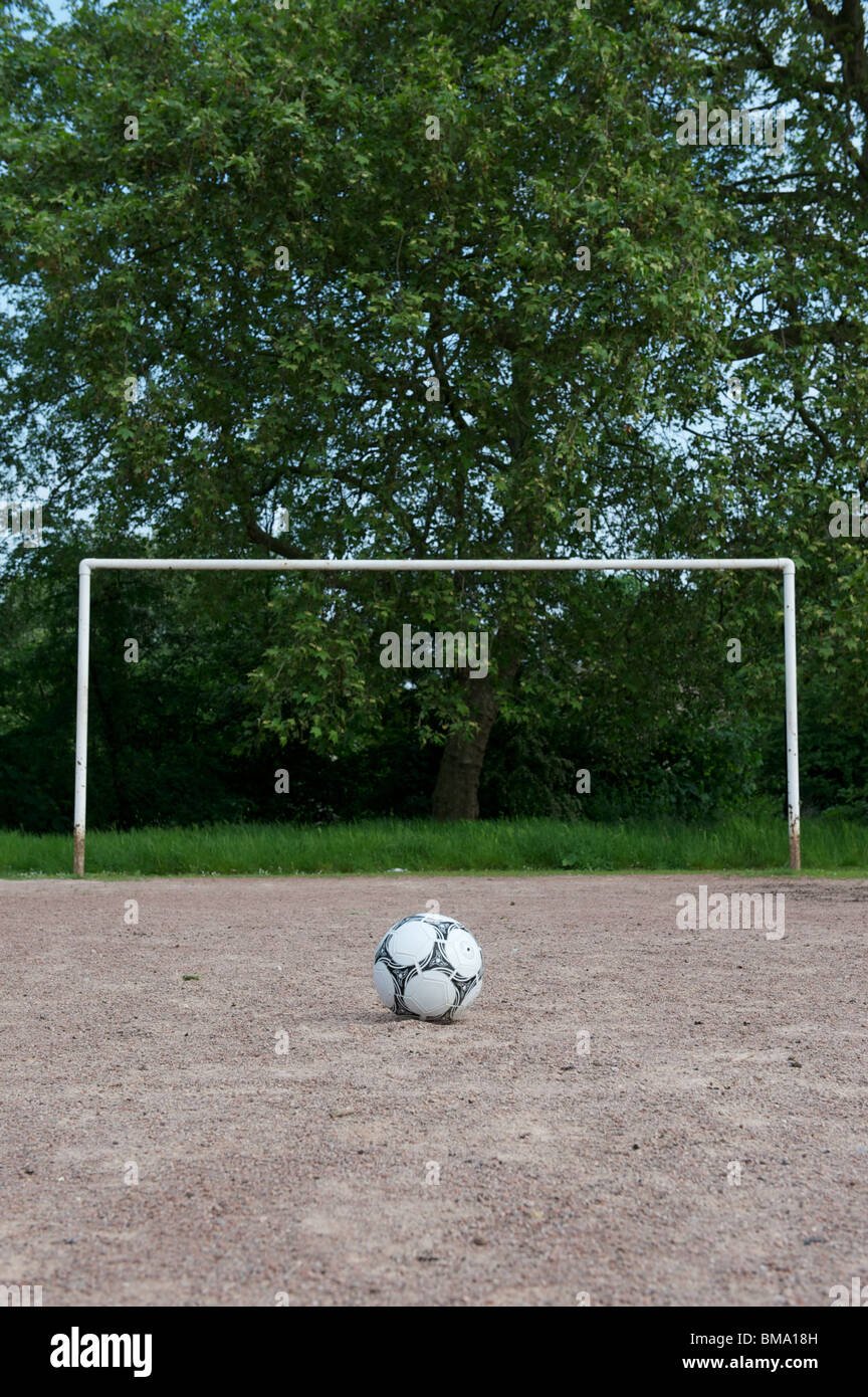 Football and goal on dirt pitch Stock Photo - Alamy