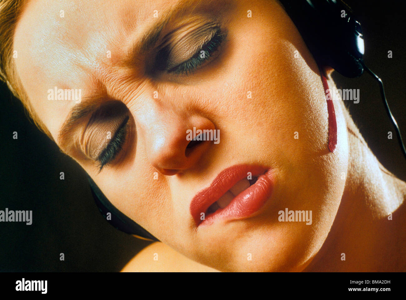 Woman with extreme expression on her face, wearing headphones Stock ...