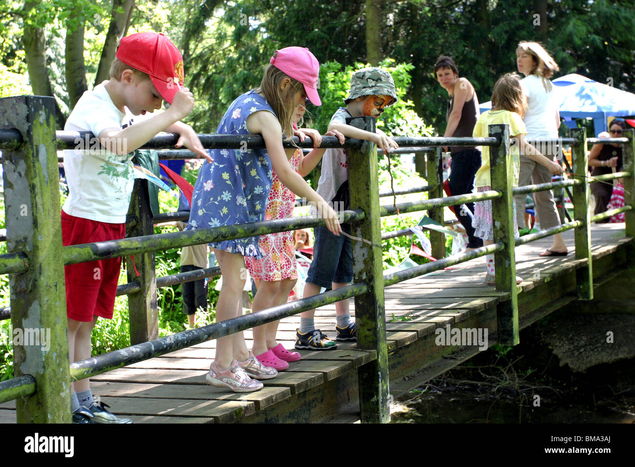 Children playing Pooh Sticks at a School Summer Fete Stock Photo - Alamy