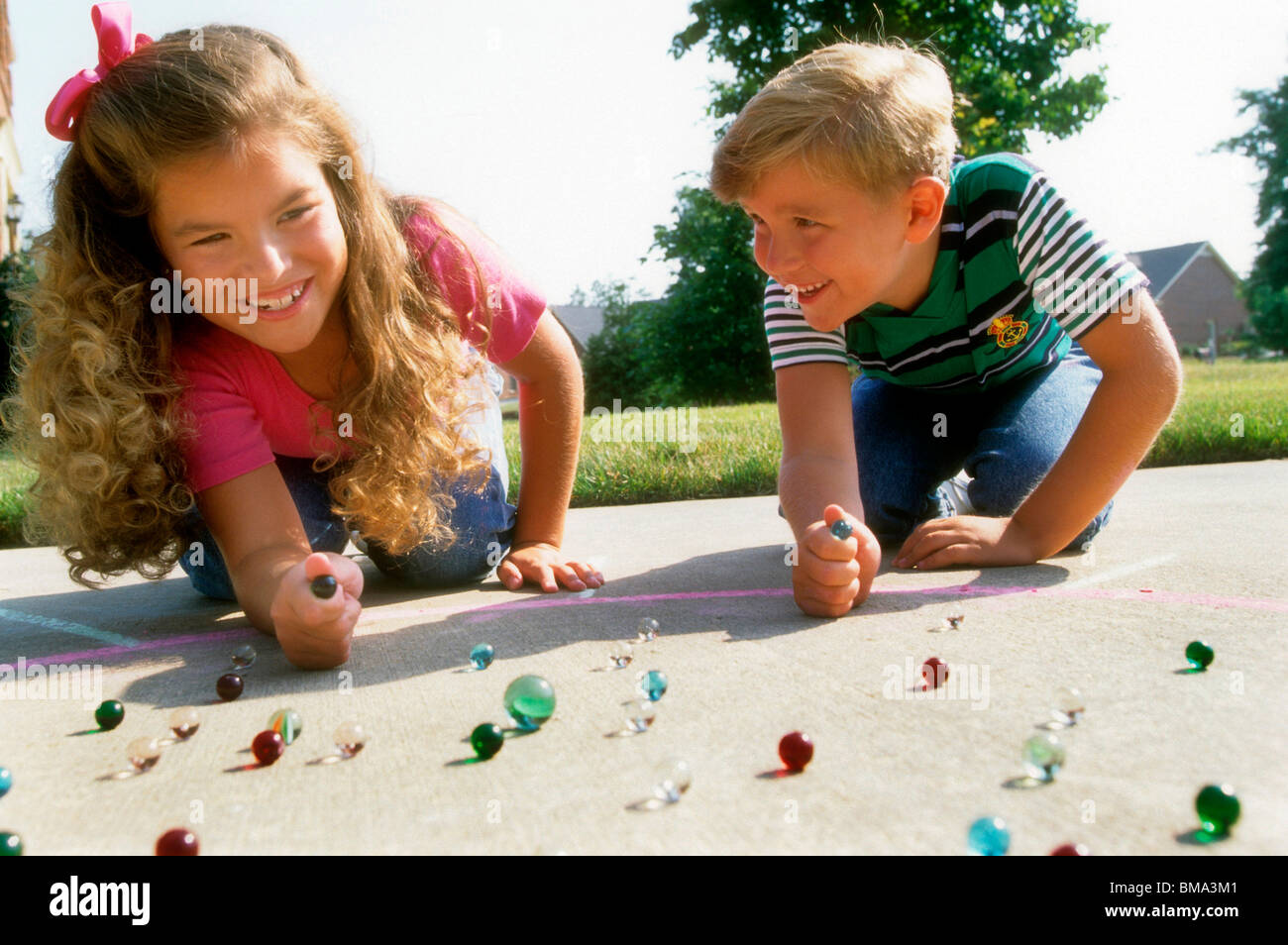 Kids playing with marbles Stock Photo - Alamy
