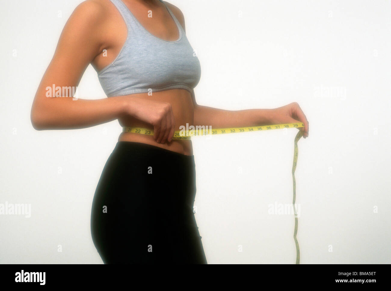 Woman measures her waist Stock Photo - Alamy