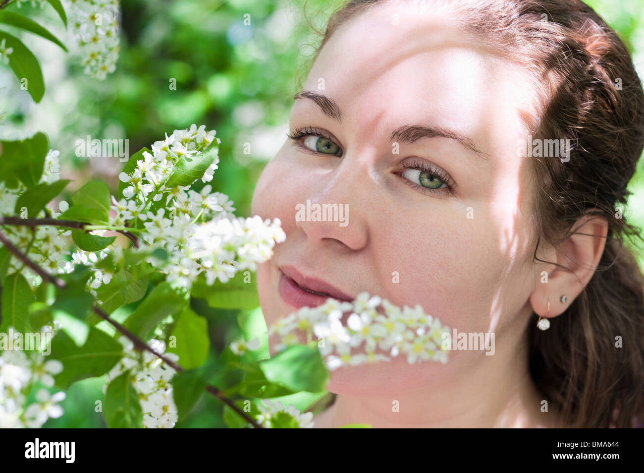 Young Woman Smelling Flower in branch of tree Stock Photo - Alamy