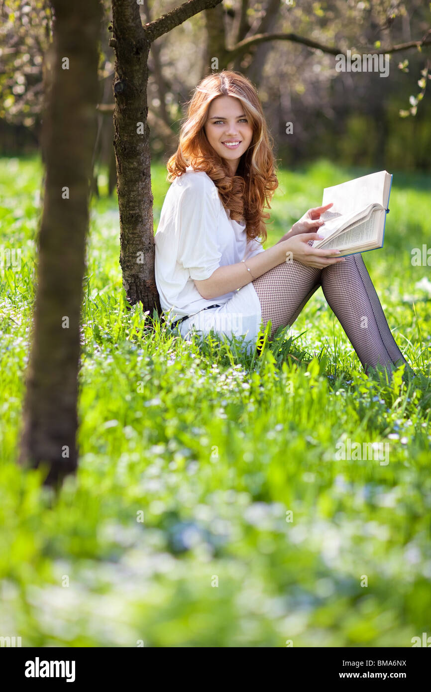 Young woman reading book in summer park Stock Photo - Alamy