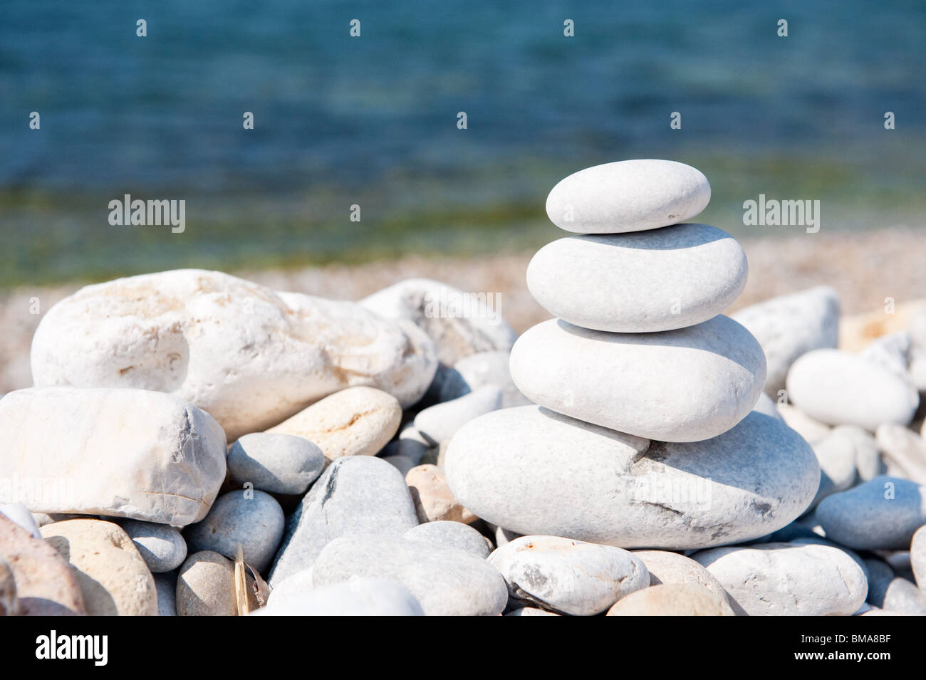 Stacked white pebbles near the coast in landscape Stock Photo - Alamy
