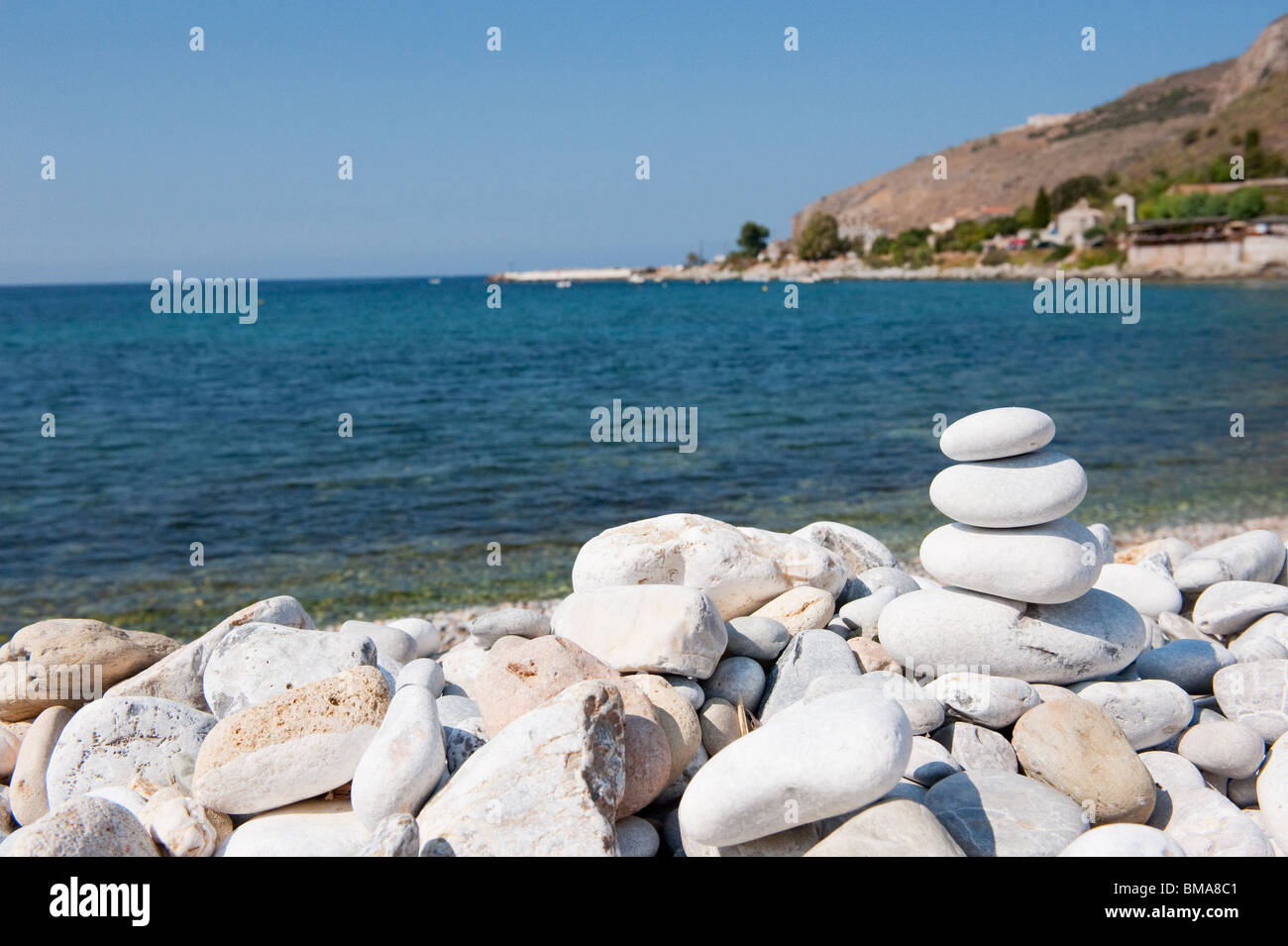 Stacked white pebbles near the coast in landscape Stock Photo - Alamy