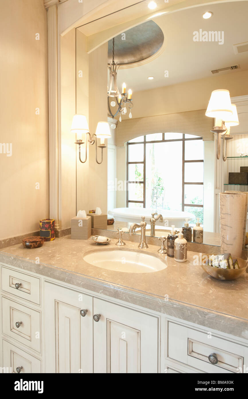 Marble topped cream bathroom with window reflected in mirror Stock ...