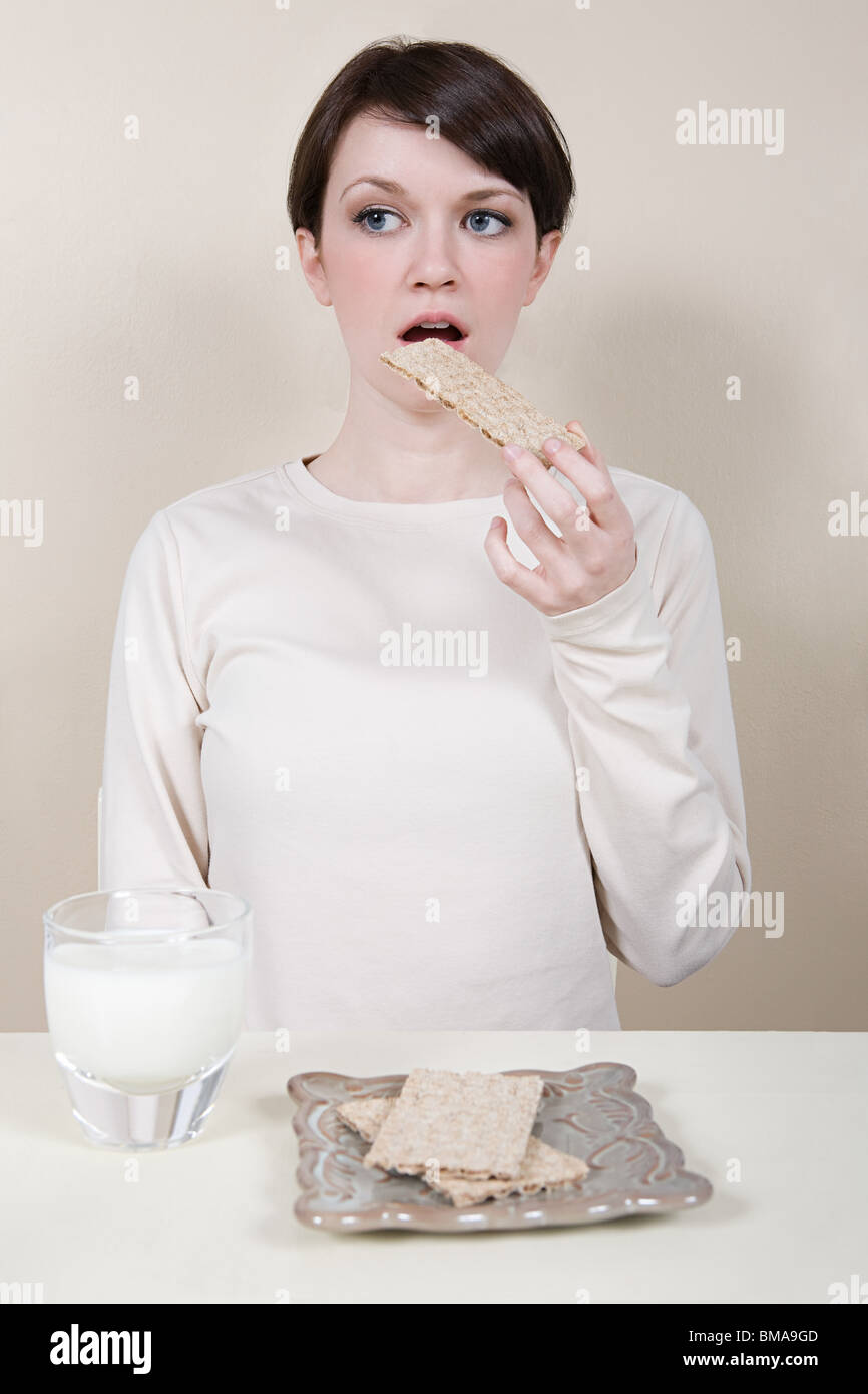 Young woman eating savoury crackers Stock Photo - Alamy