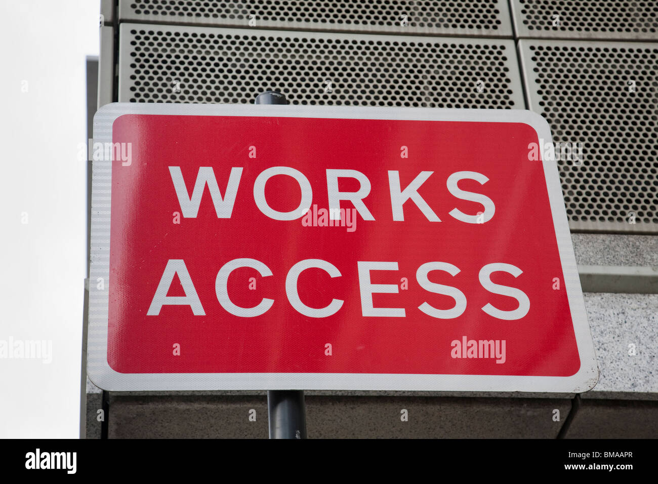 A red works access sign on an office building in the City of London ...