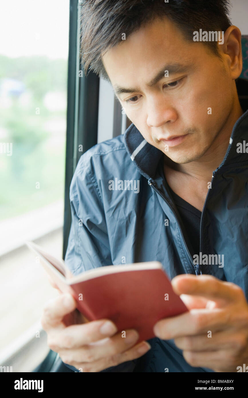 Man Reading Book on Train Stock Photo - Alamy