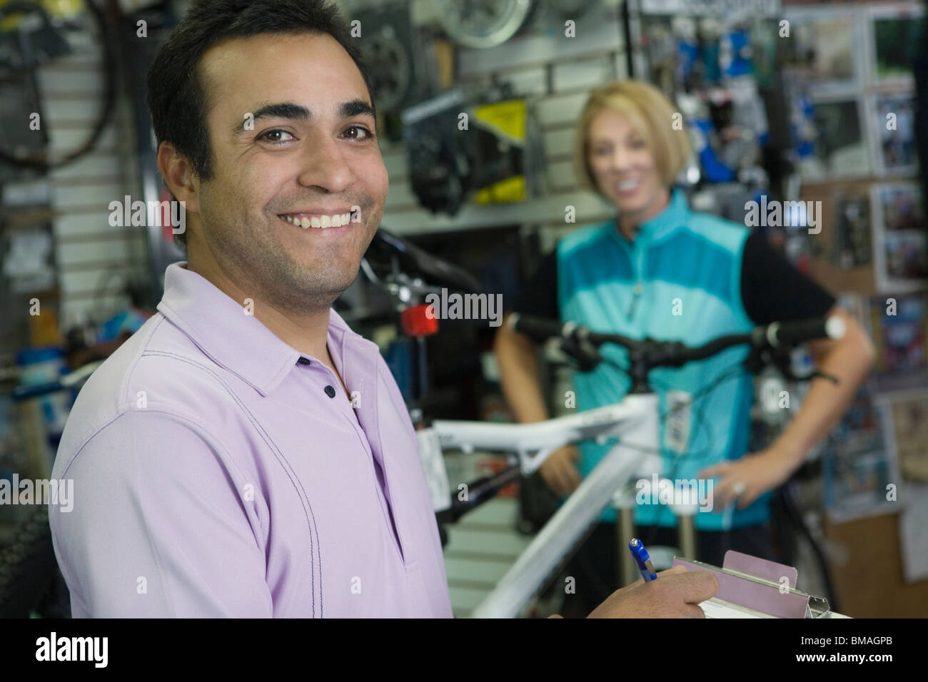 Bike shop assistant with female cyclist Stock Photo - Alamy