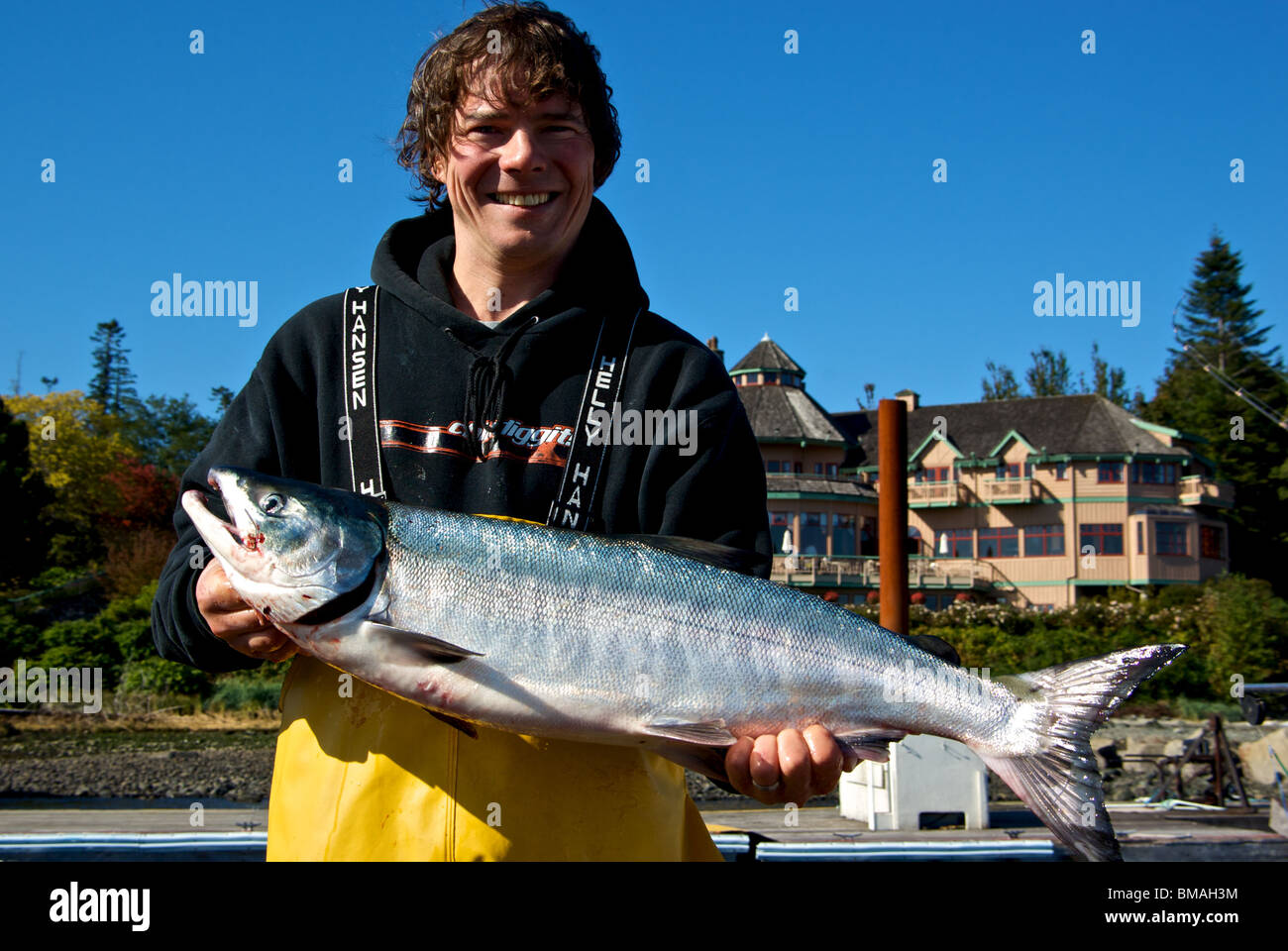 Young man holding silver bright autumn chum salmon (Oncorhynchus keta ...