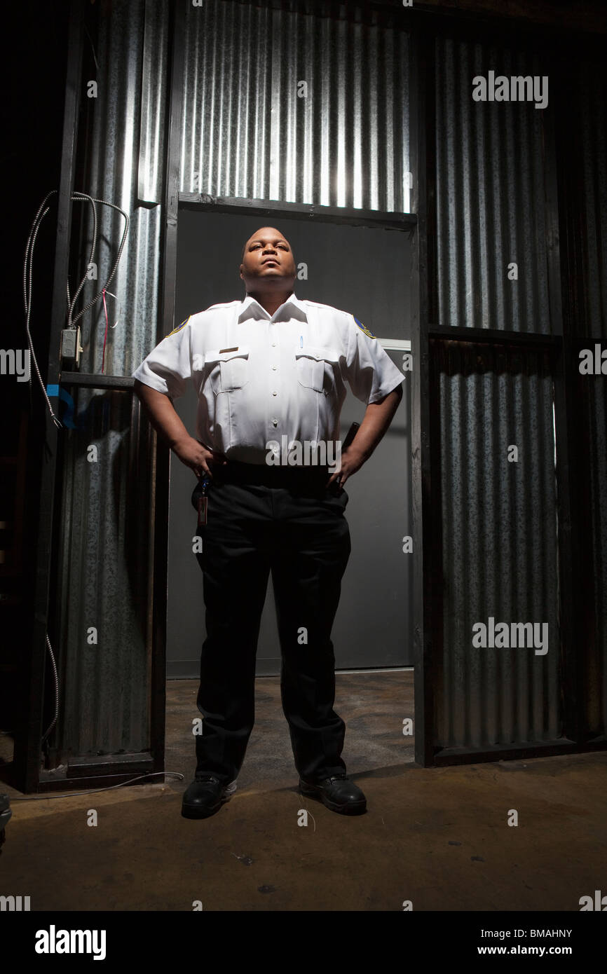Security guard stands at corrugated metal doorway Stock Photo - Alamy