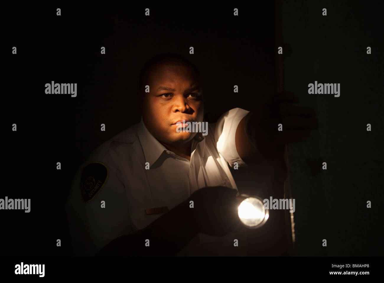 Security guard investigates with flashlight Stock Photo - Alamy