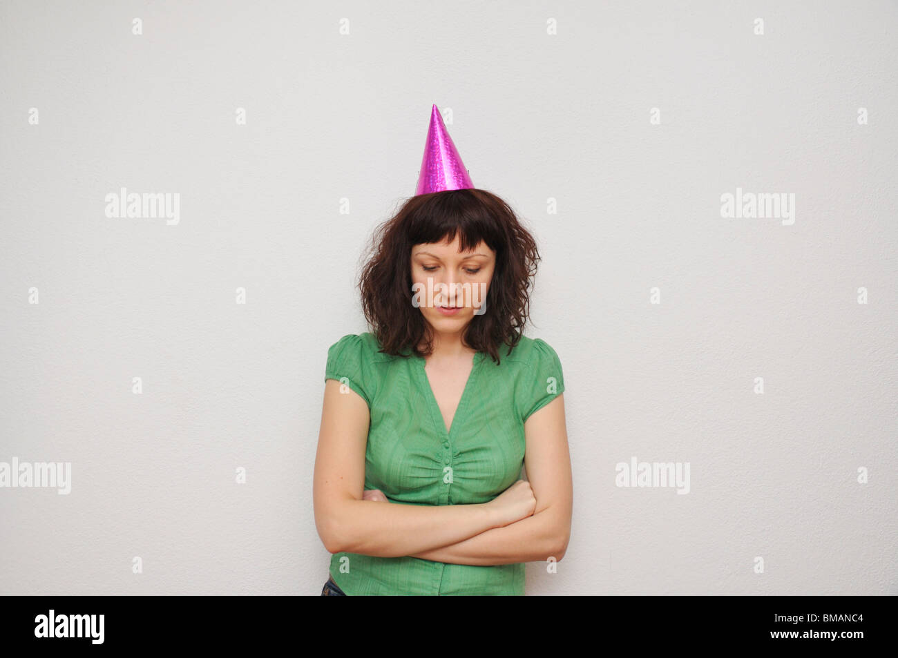 Sad young woman wearing party hat Stock Photo - Alamy