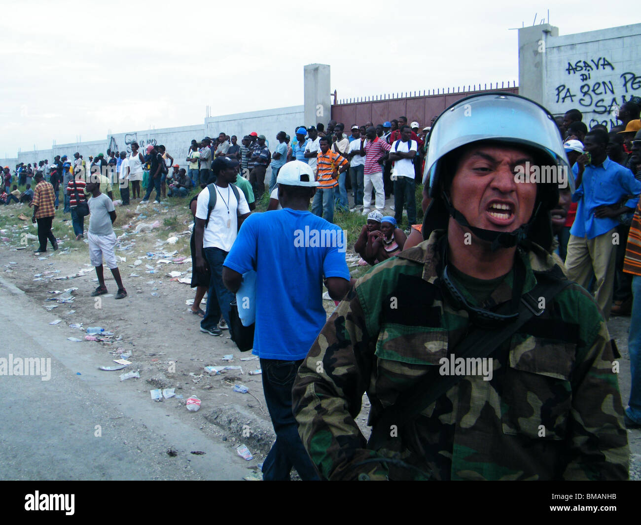 A United Nations (MINUSTAH) officer shouts outside an aid centre in ...