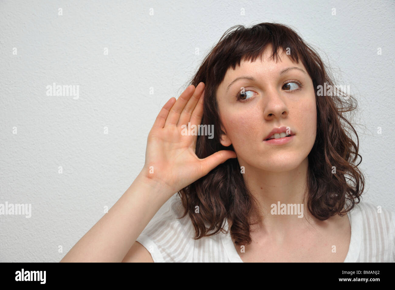 Woman cupping her ear hi-res stock photography and images - Alamy