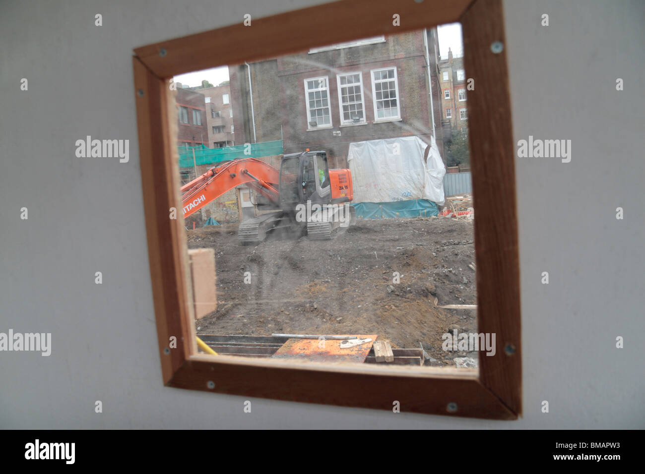A pedestrian viewing window at a construction site in Central London ...