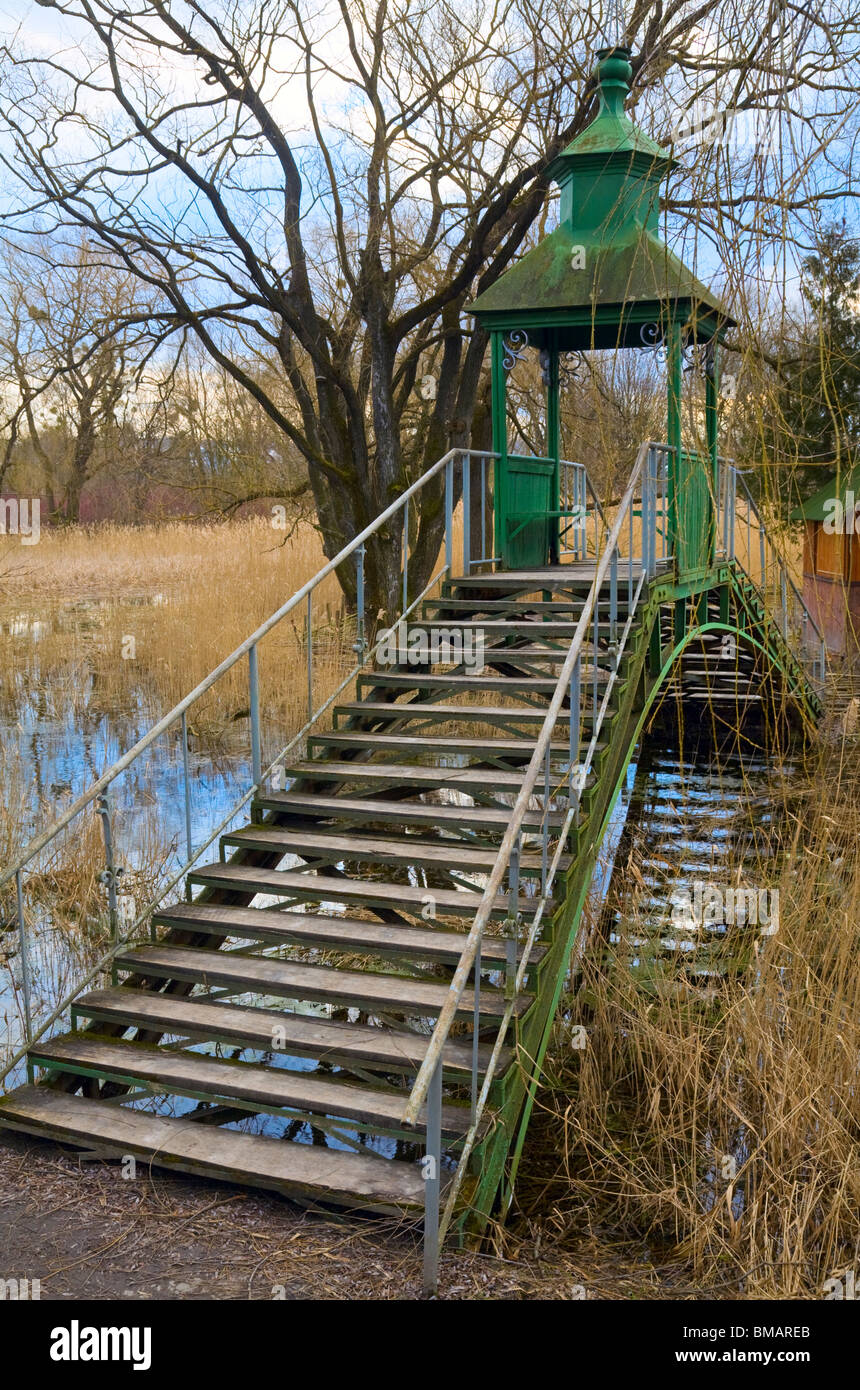 Spring dull view of plant-filled pond and bridge over water Stock Photo ...