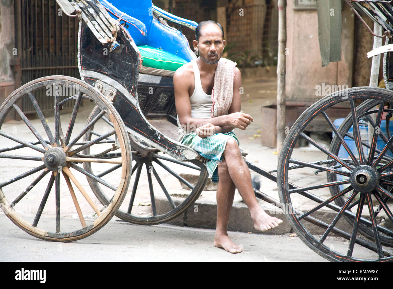 Manual labor hand rickshaw puller sitting in his vehicle ; Park street ...