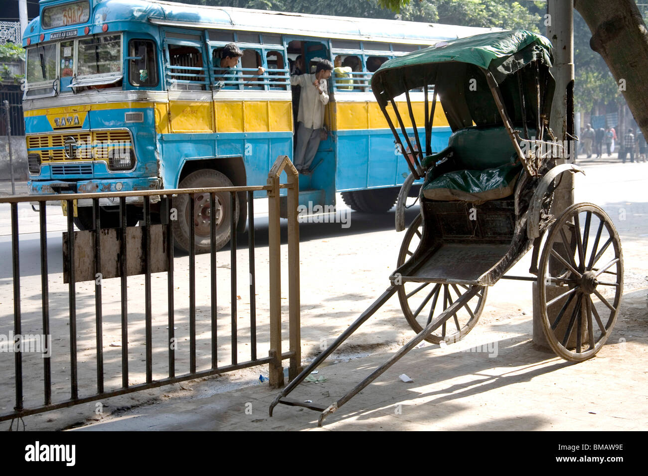 Empty rickshaw and bus standing ; Calcutta now Kolkata ; West Bengal ...