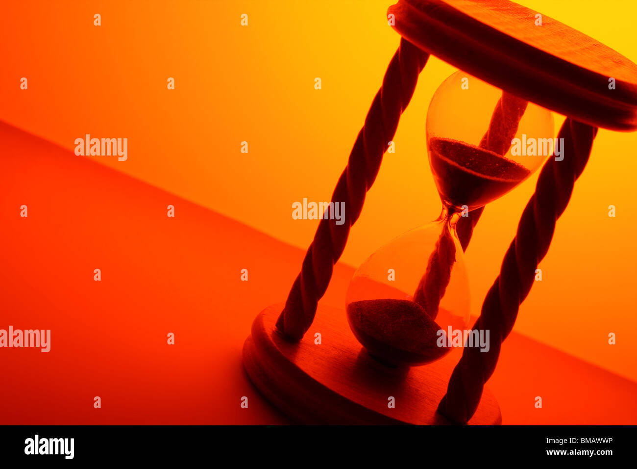 Hourglass in orange light Stock Photo - Alamy