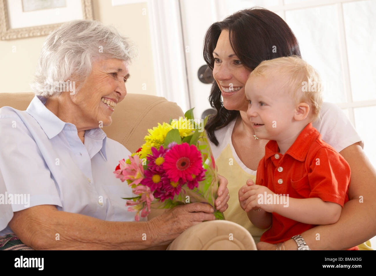 A Young Child Giving Flowers To His Grandmother Stock Photo - Alamy