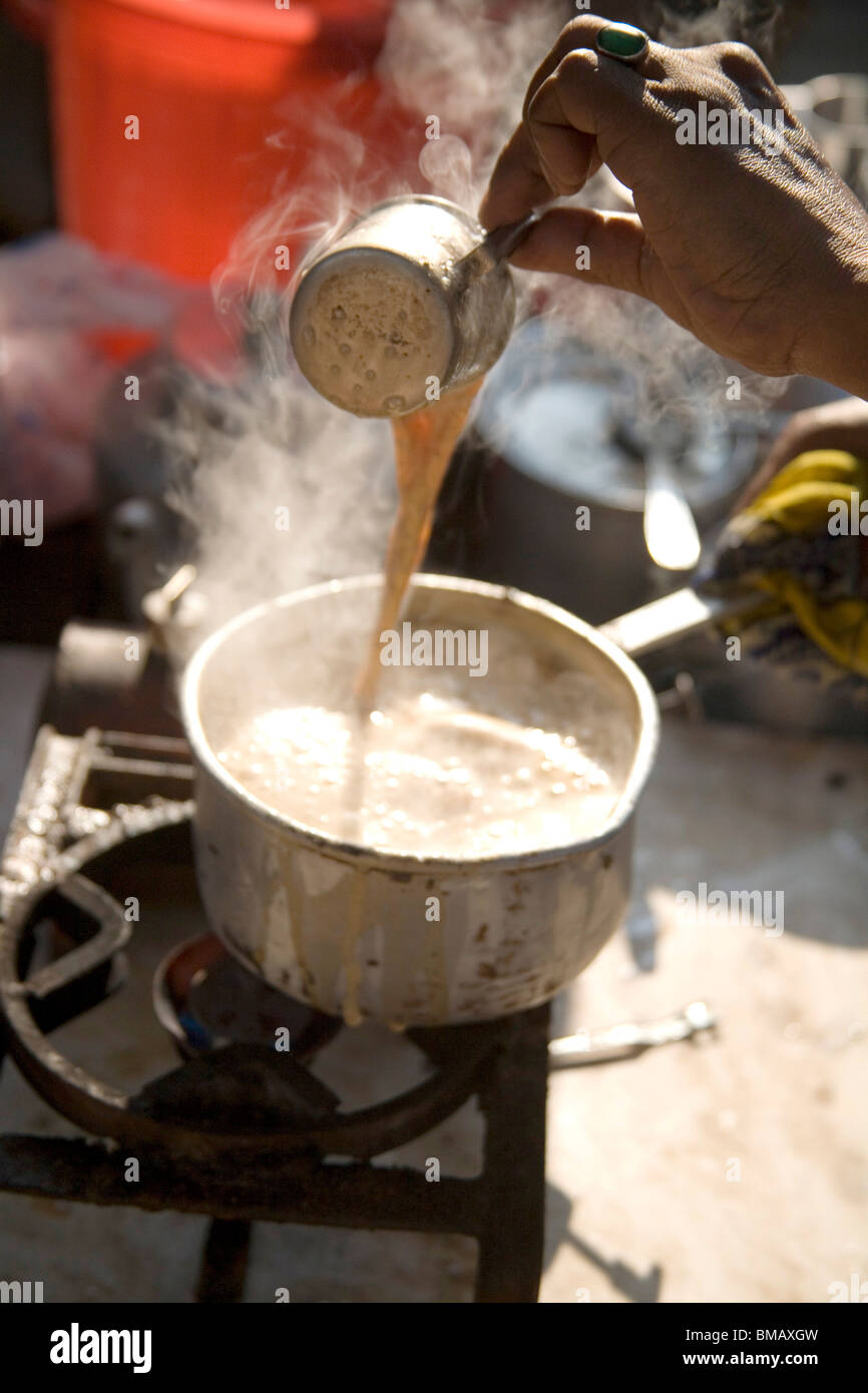Tea vendor hand pouring steam tea from cup into teapot; Calcutta now ...