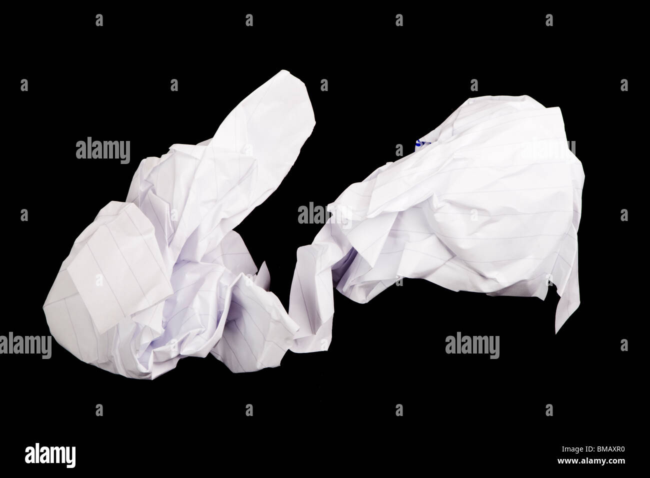 Two pieces of screwed up paper on a black background Stock Photo - Alamy