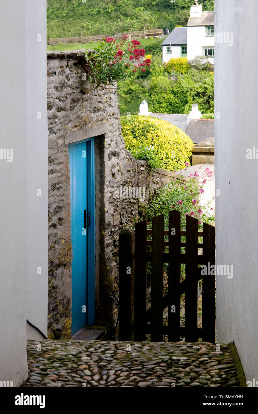 A wooden gate on a cobbled path between two houses overlooking the ...