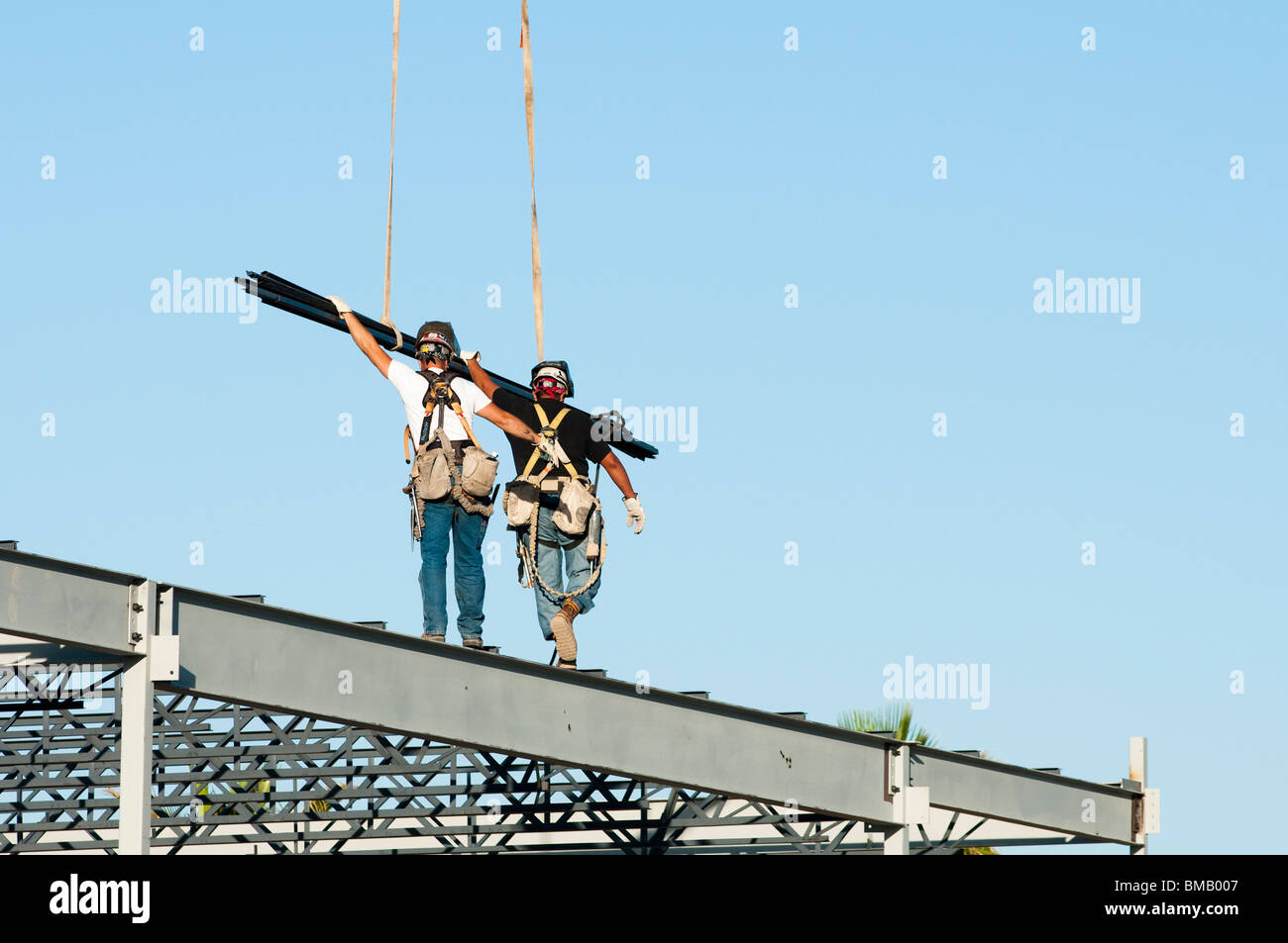 steelworkers erect the structural steel framework for a commercial ...