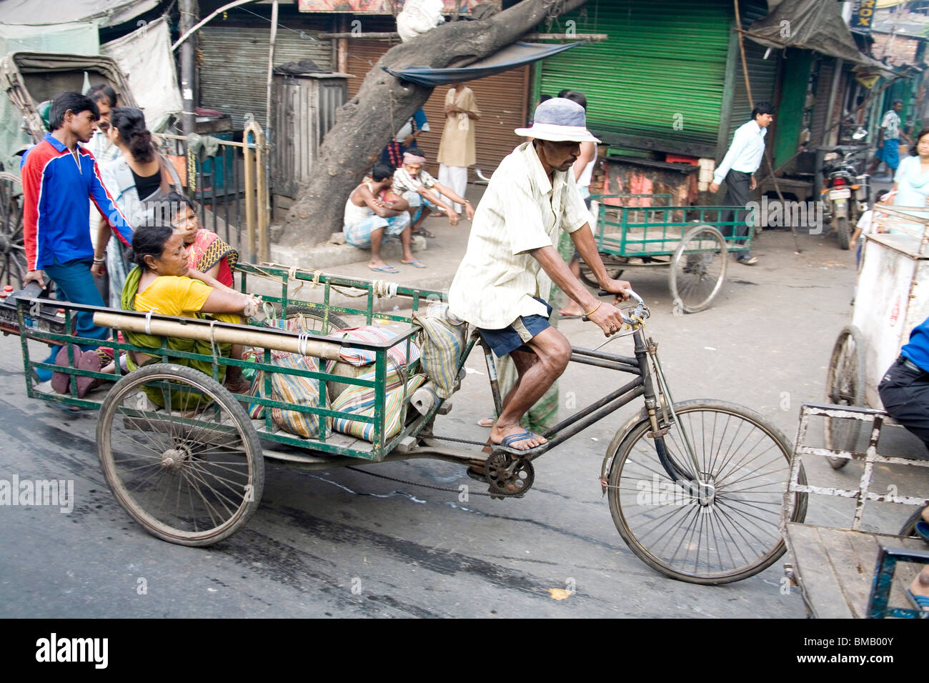 Street scene ; cycle rickshaw riders with passengers ; Calcutta now ...